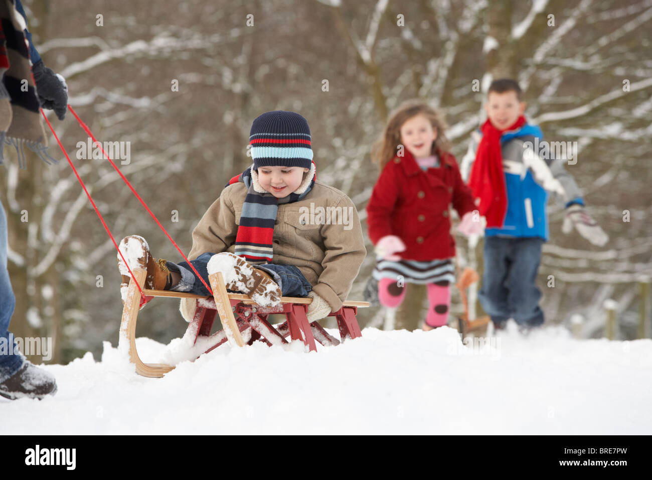 Boy pulling girl on sledge hi-res stock photography and images - Alamy
