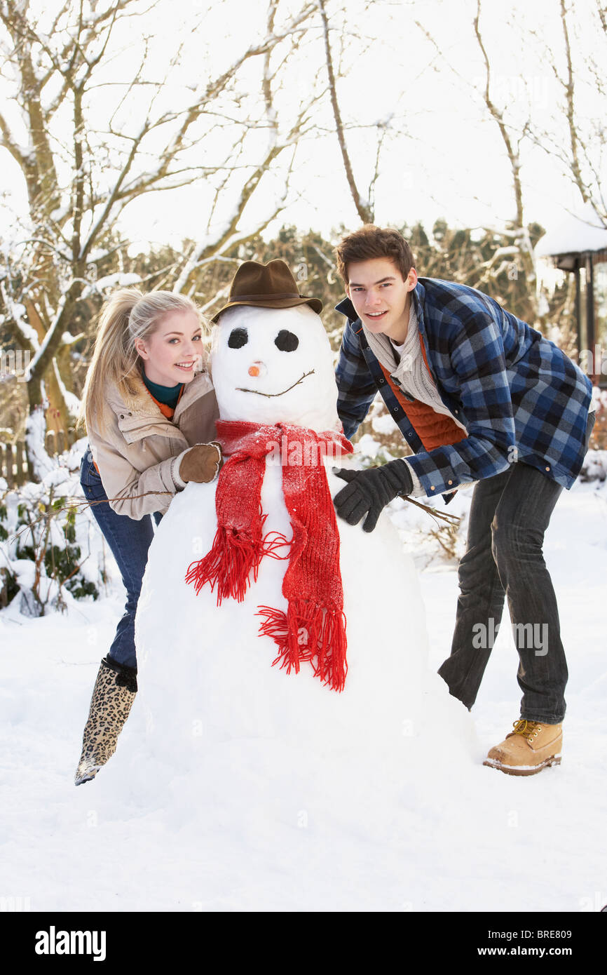 Teenage Couple Building Snowman Stock Photo - Alamy
