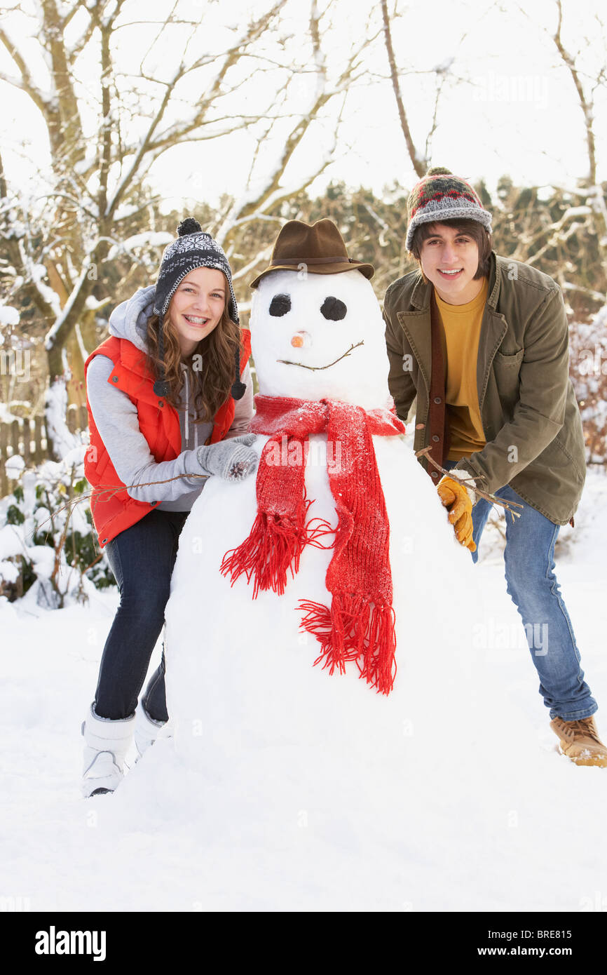 Teenage Couple Building Snowman Stock Photo - Alamy