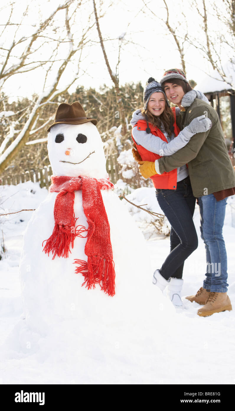 Teenage Couple Building Snowman Stock Photo - Alamy