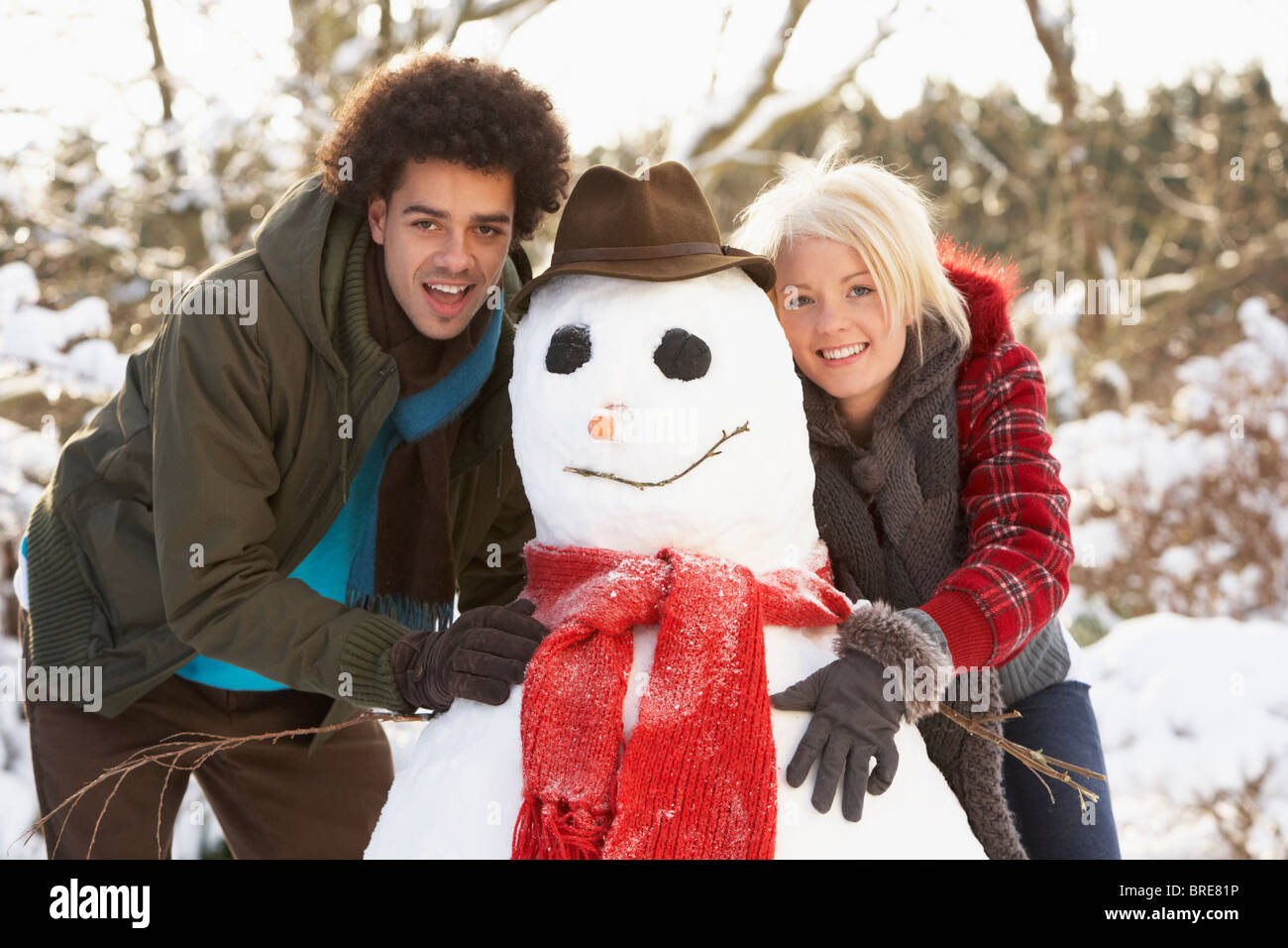 Teenage Couple Building Snowman Stock Photo - Alamy