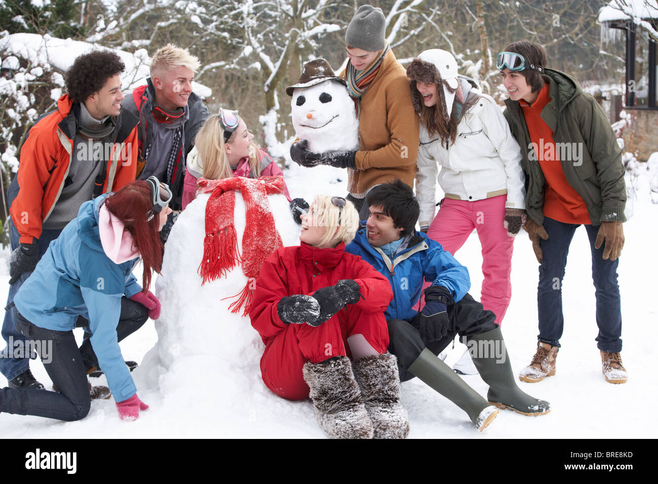 Group Of Teenage Friends Building Snowman In Garden Stock Photo - Alamy