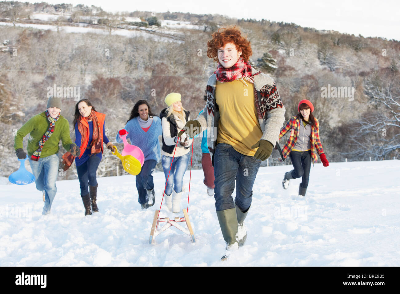 Group Of Teenage Friends Sledging In Snowy Landscape Stock Photo - Alamy