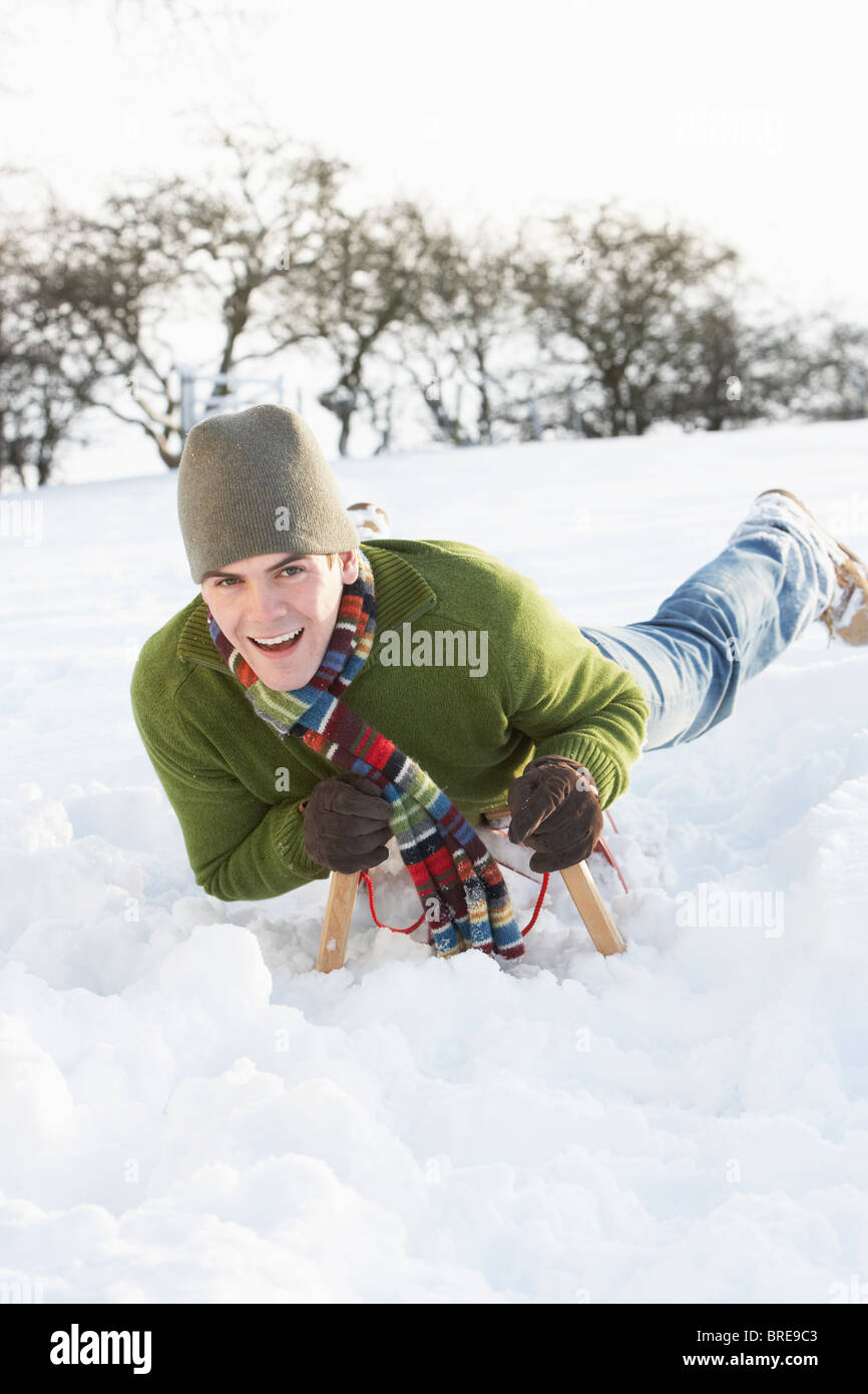 Young Man Riding On Sledge In Snowy Landscape Stock Photo - Alamy