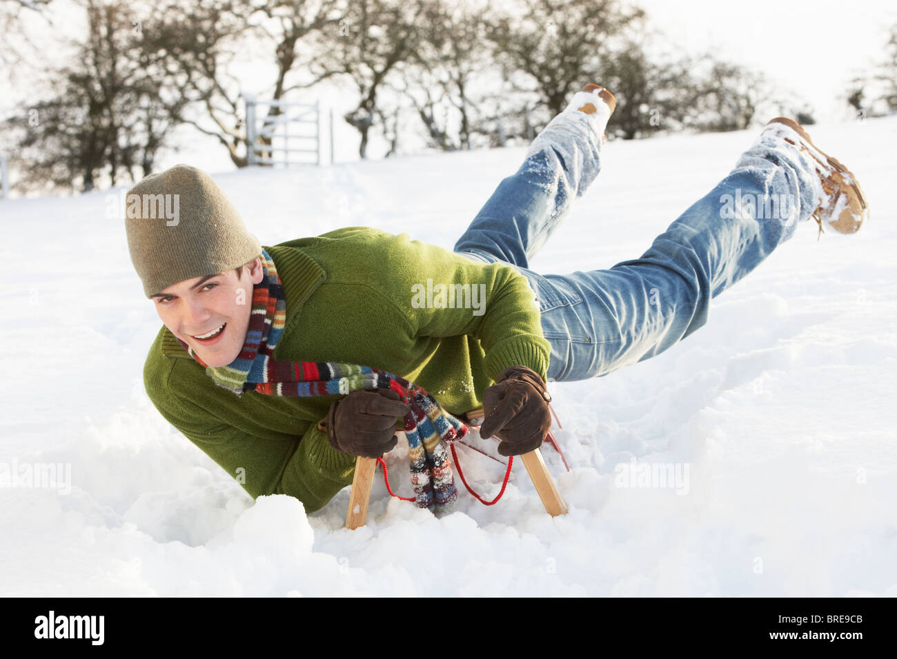 Young Man Riding On Sledge In Snowy Landscape Stock Photo - Alamy