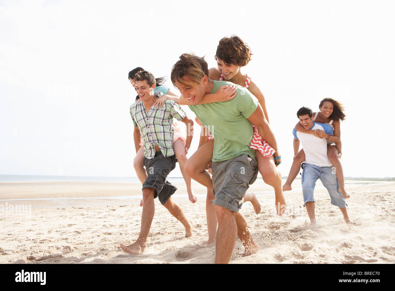 Group Of Friends Running Along Beach Together Stock Photo - Alamy
