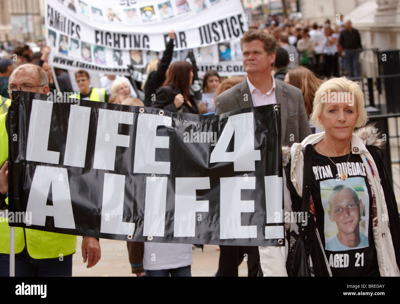 The mother of Ryan Dugdale, killed in a arson attack, holds a banner ...