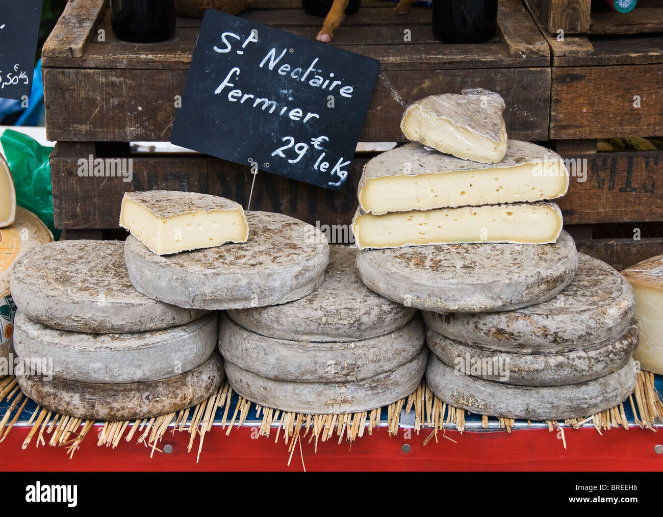 Farmhouse cheeses on a village market stall in France. The cheese is ...