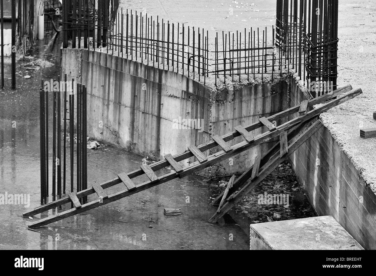 Rusty steel bars and ladders at construction site on rainy day. Black ...