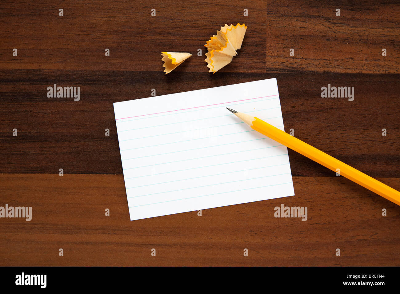 Blank index card with sharp pencil and shavings on wooden desk, view ...