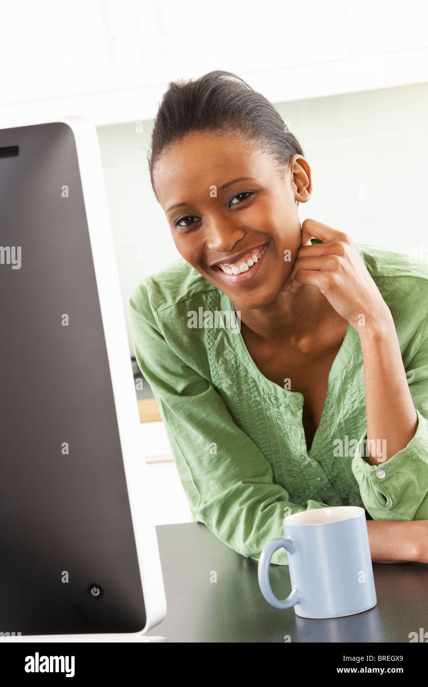 Young Woman Using Computer In Modern Kitchen Stock Photo - Alamy