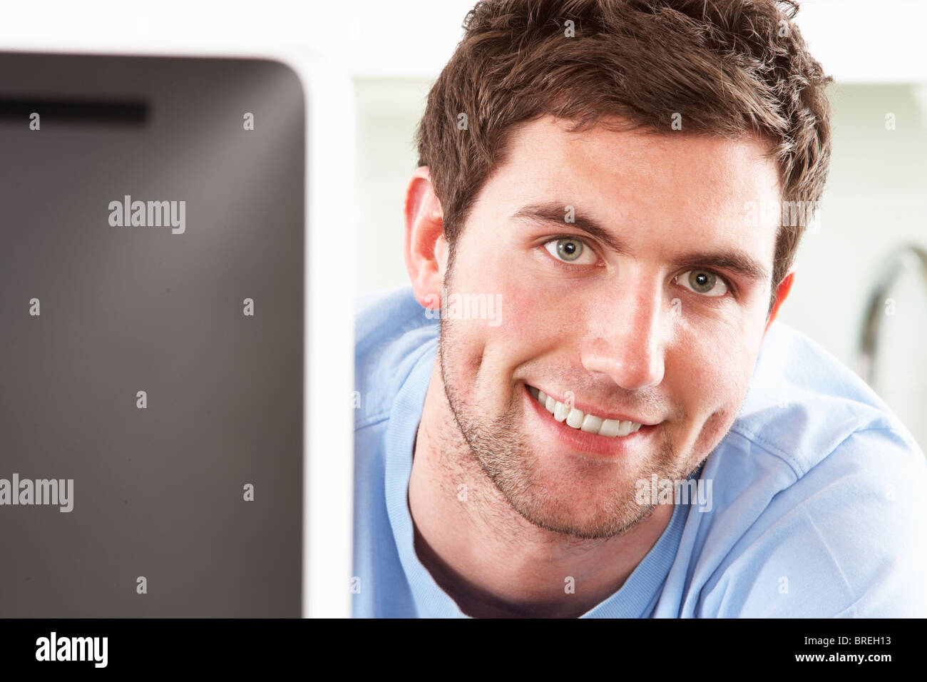Young Man Using Computer In Modern Kitchen Stock Photo - Alamy