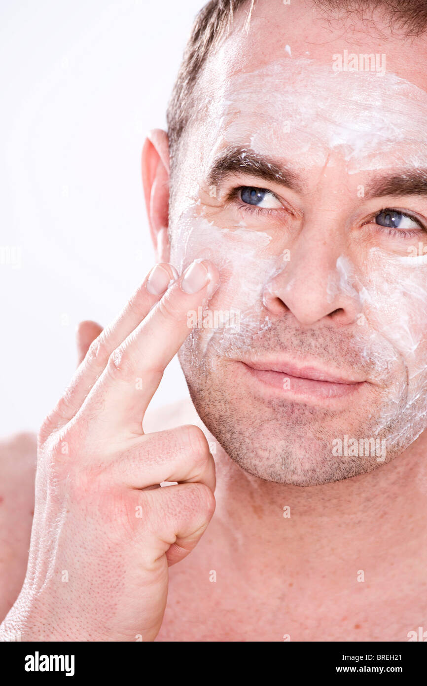 Man putting on lotion Stock Photo - Alamy