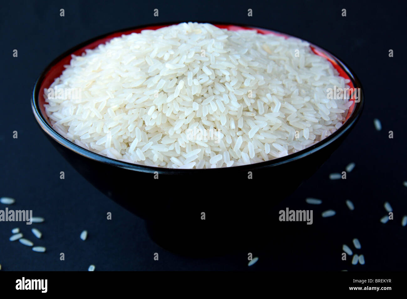 White rice in a cup of black on black background Stock Photo - Alamy