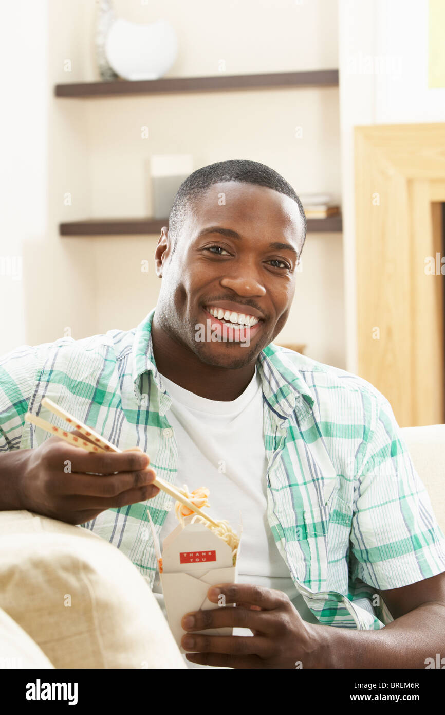 Young Man Relaxing Sitting On Sofa At Eating Chinese Meal At Home Stock ...