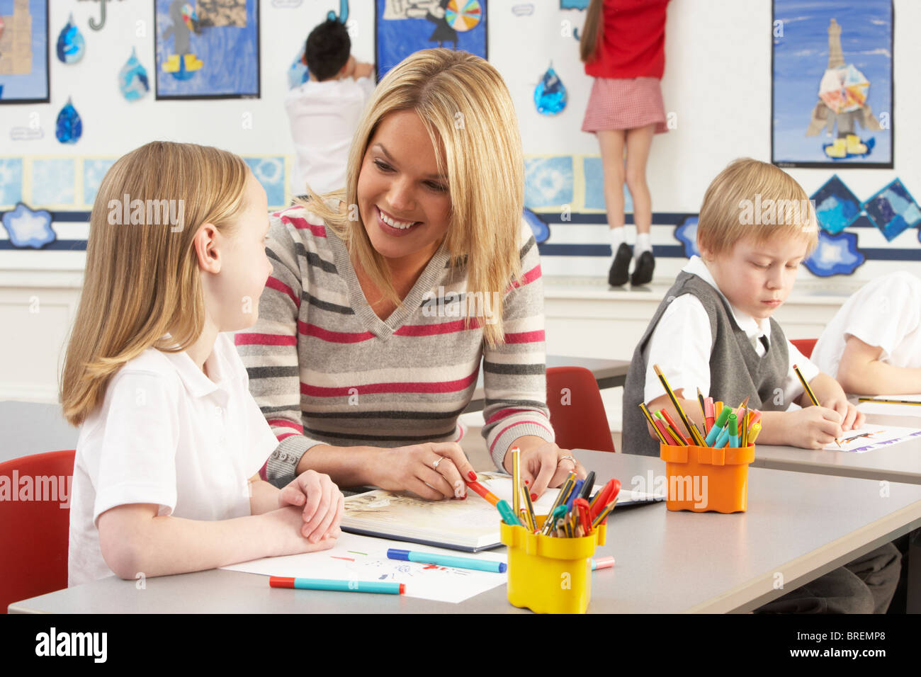 Group Of Primary Schoolchildren And Teacher Having lesson In Classroom ...
