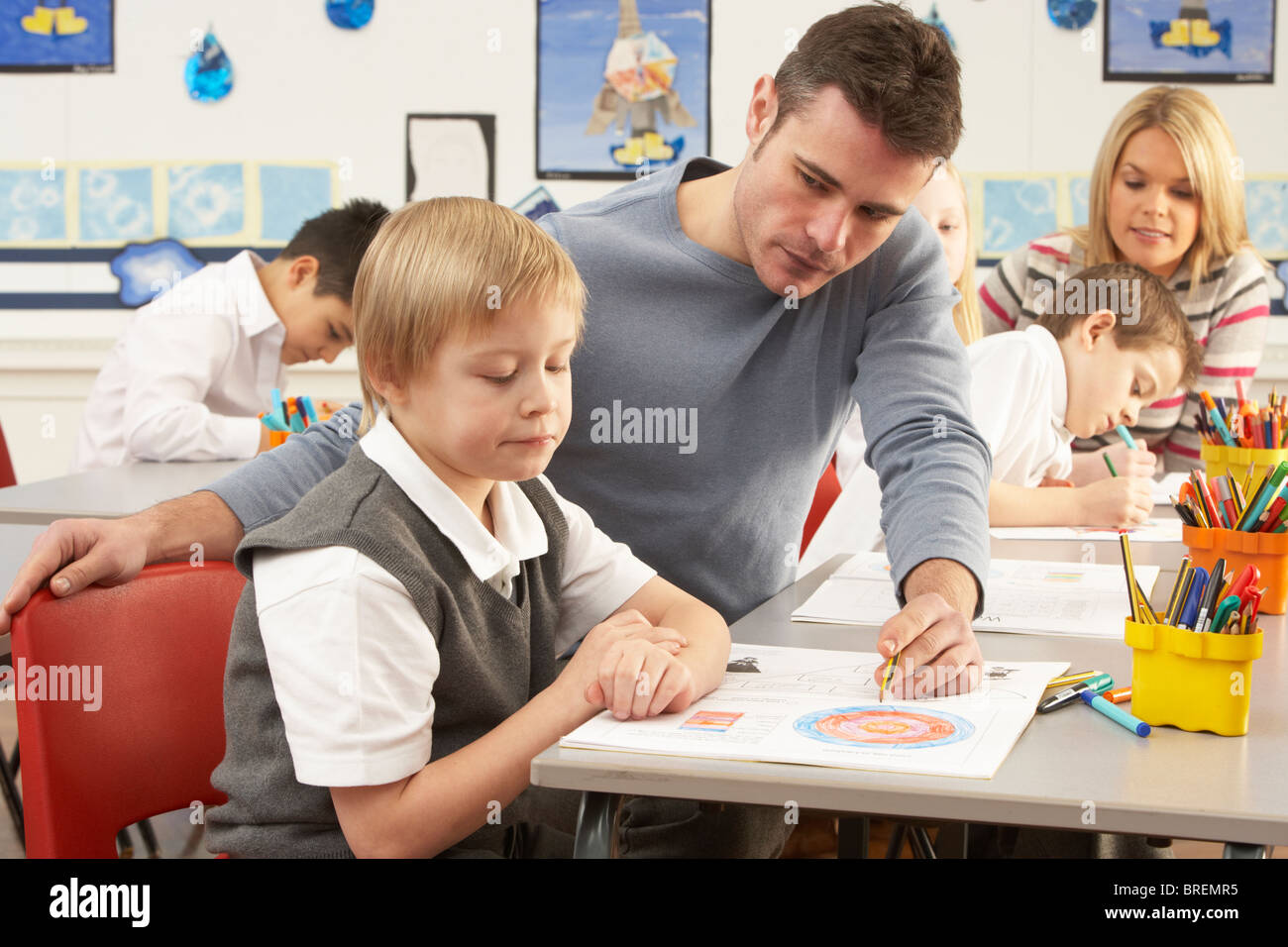 Group Of Primary Schoolchildren And Teacher Having lesson In Classroom ...
