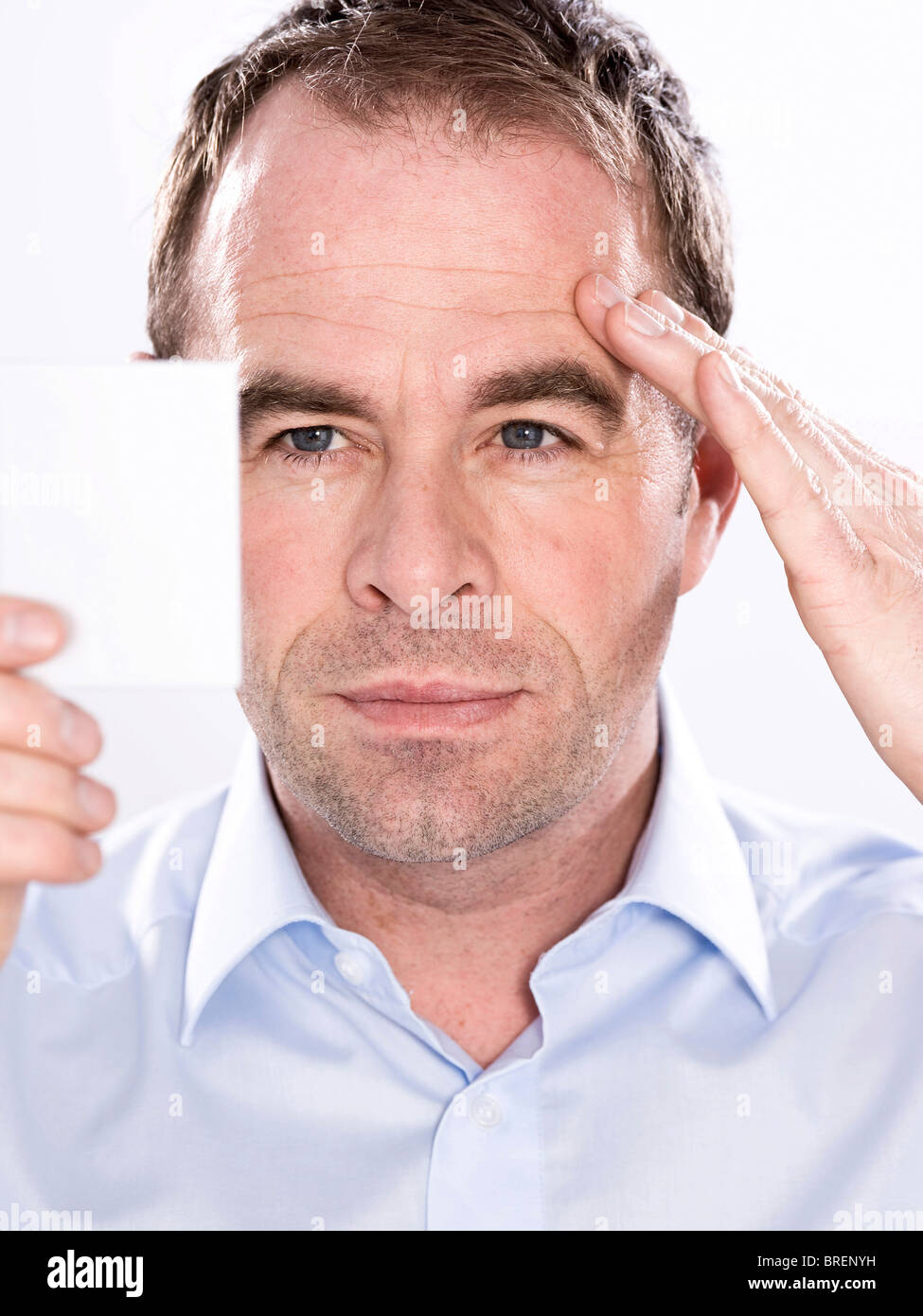 Man looking into a mirror to examine his wrinkles Stock Photo - Alamy