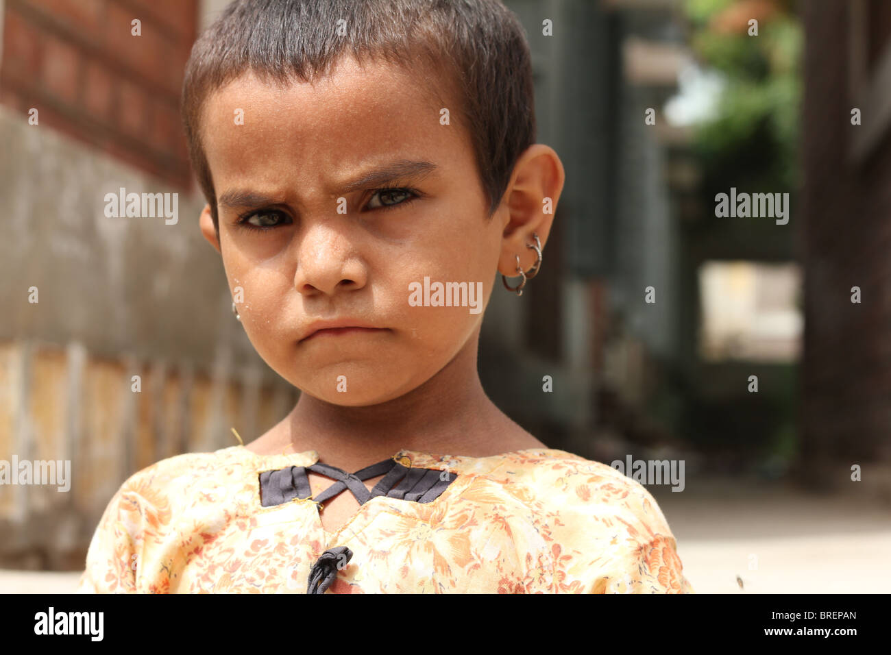 A Cute Refugee Girl scowls at the camera at a Refugee Camp setup for ...