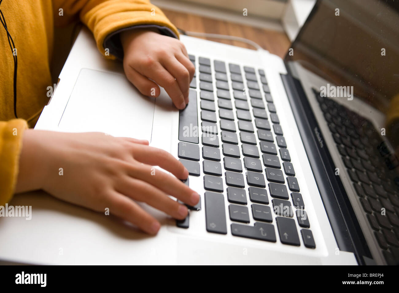 young boy playing games on an apple mac computer on a train journey ...