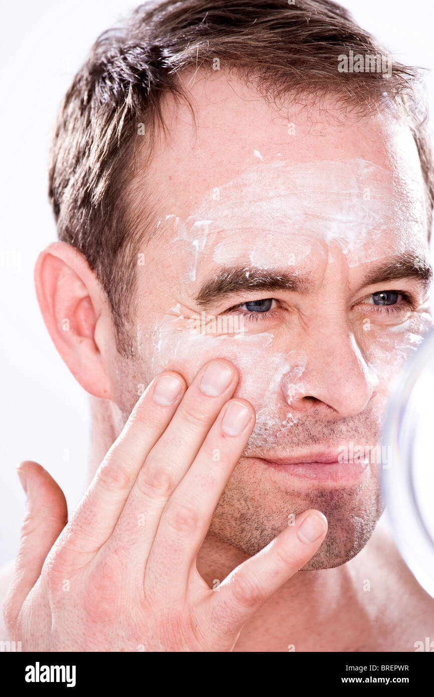 Man putting on lotion Stock Photo - Alamy