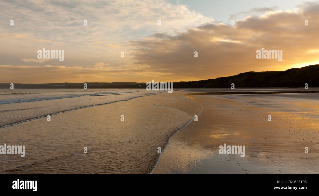 Sunset and clouds reflected on the sandy beach at Filey in North ...