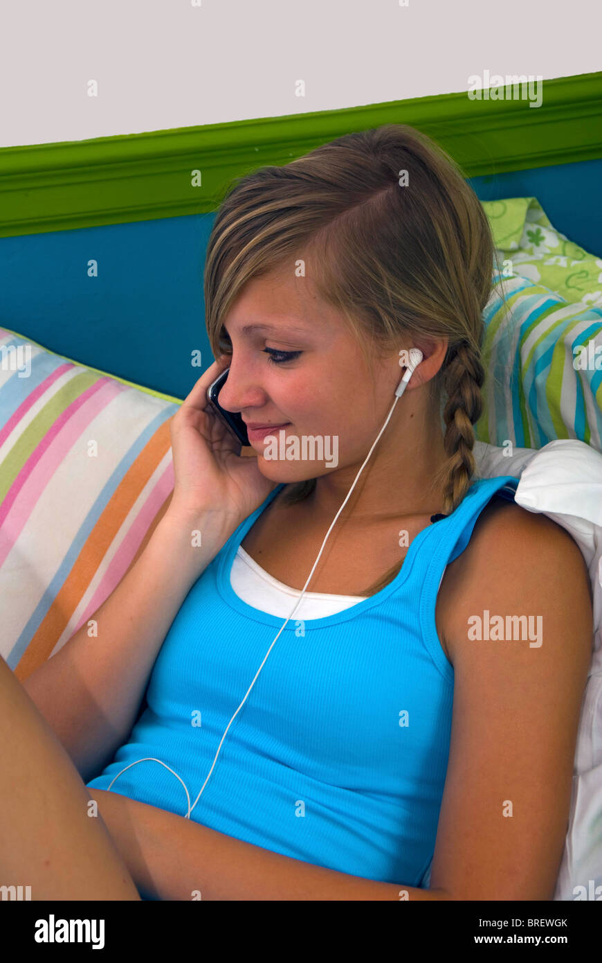 Teenage girl on cell phone smiling smirking with headphones Stock Photo ...