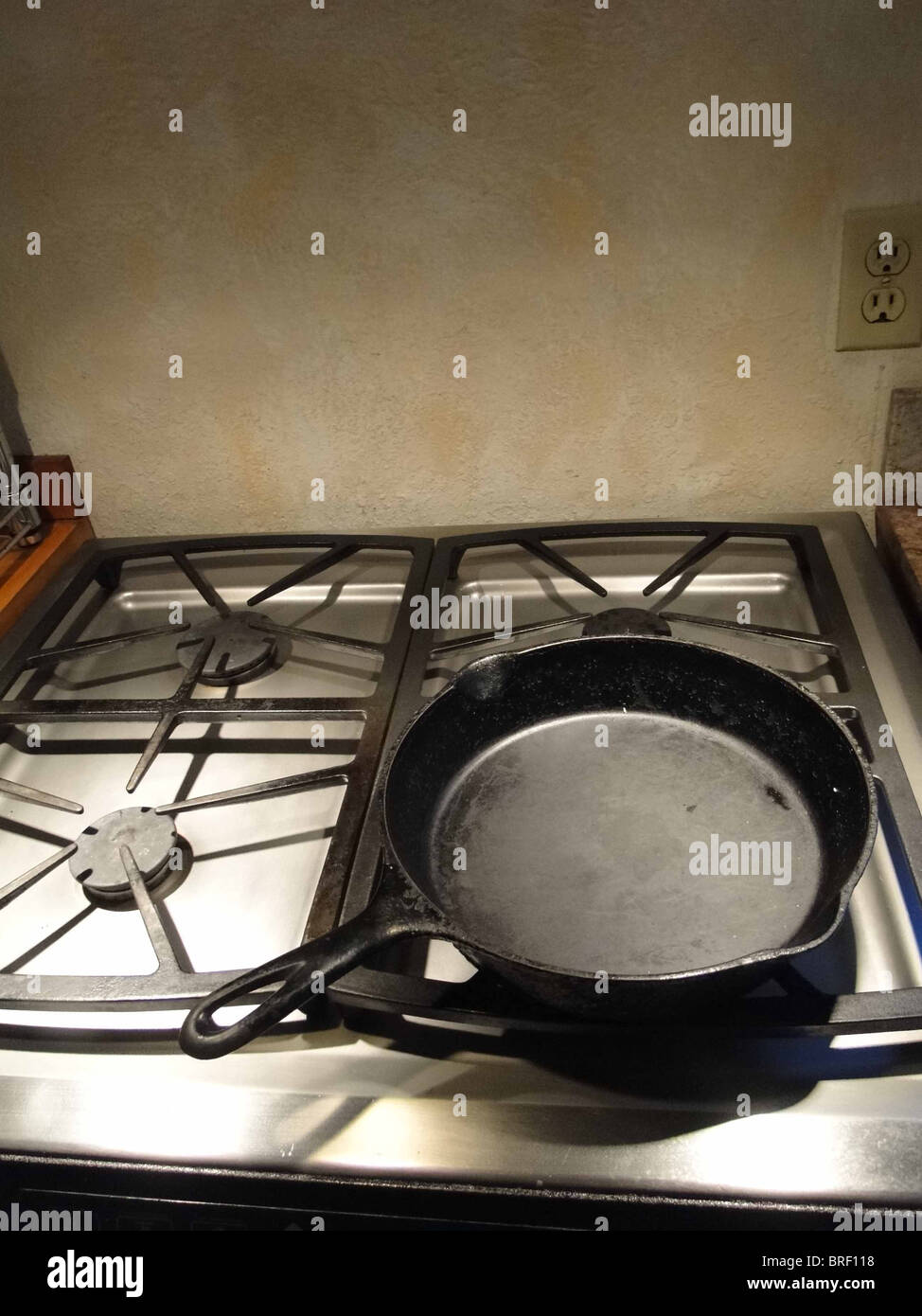 Large cast iron frying pan on gas stove in kitchen Stock Photo - Alamy