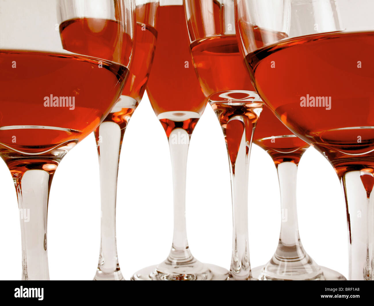 Wine glasses on a white background filled with various levels of a red ...