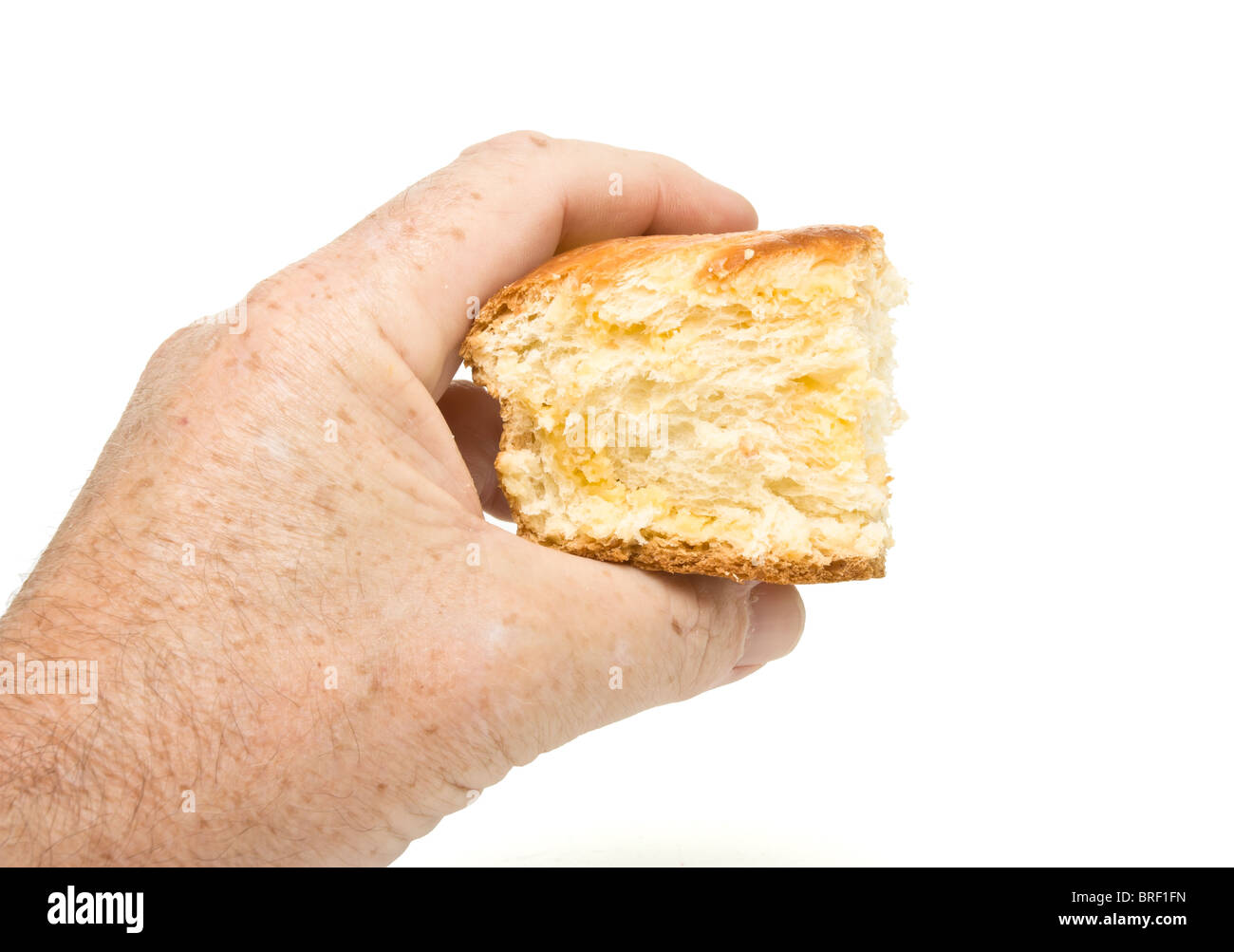 Male hand holding chunk of Brioche laced with creme custard isolated on ...