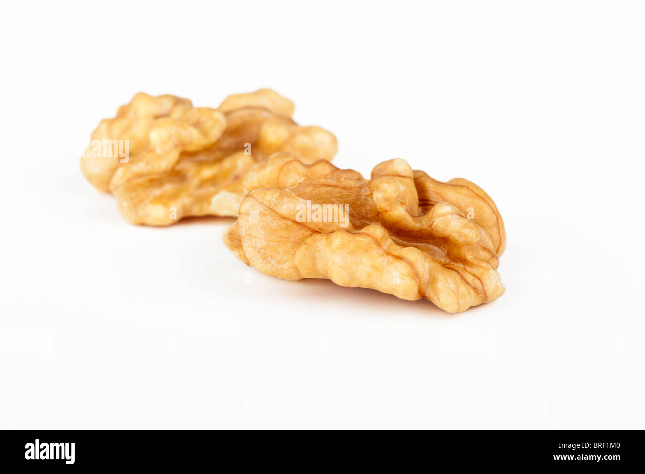 Two raw shelled walnut halves on white background Stock Photo - Alamy