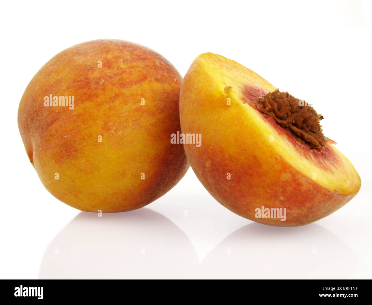 One whole peach and one half peach with stone on white Stock Photo - Alamy