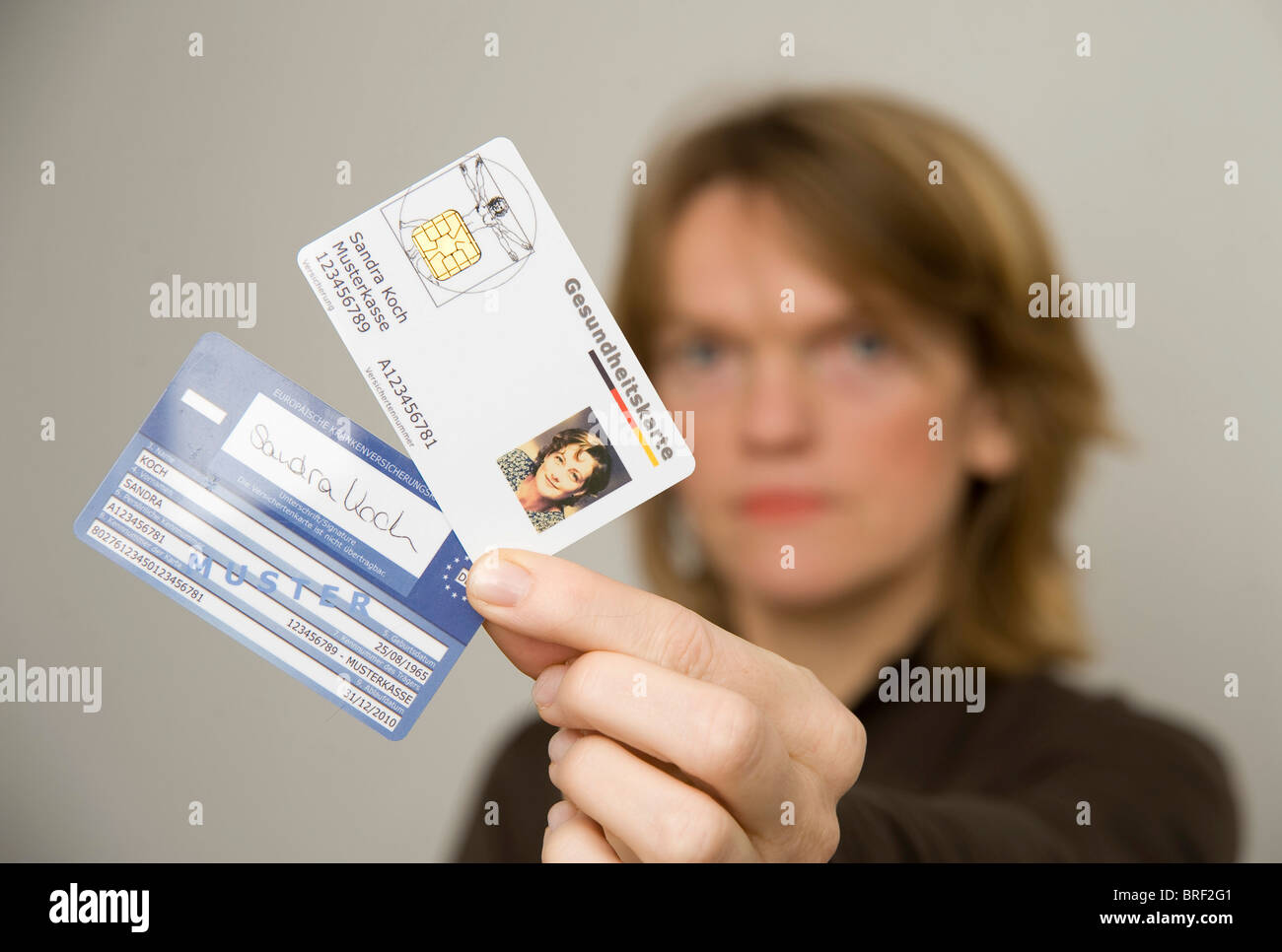 Woman holding German electronic health insurance cards Stock Photo - Alamy