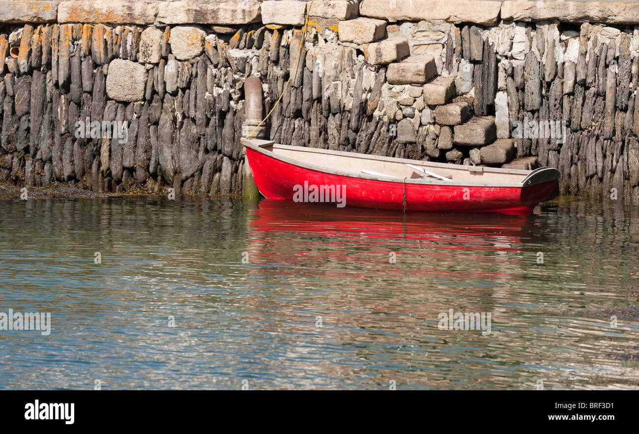 Steps to a red dingy. Rough stone steps lead down to a bright red dingy ...