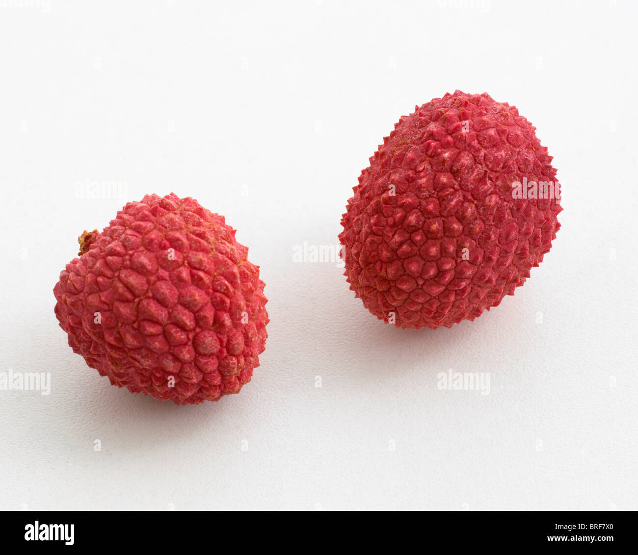 Two lychees on white background Stock Photo - Alamy