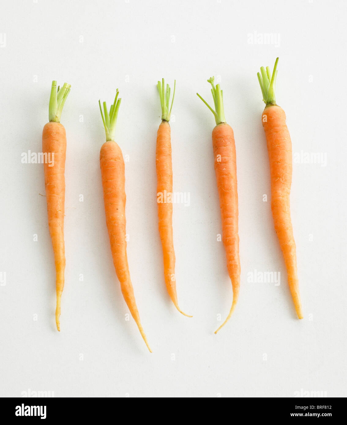 Five carrots on white background Stock Photo - Alamy
