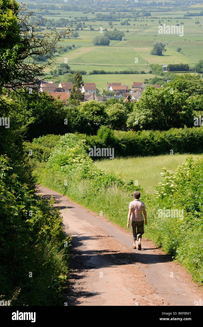 Woman walking down country lane hi-res stock photography and images - Alamy