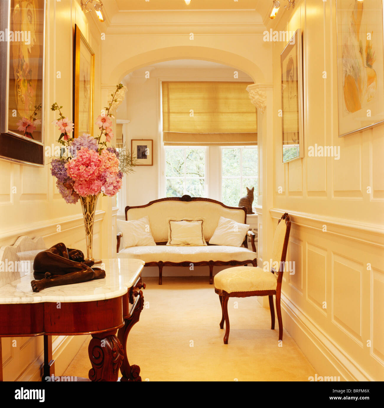 Sideways view of marble-topped console table and antique sofa below ...