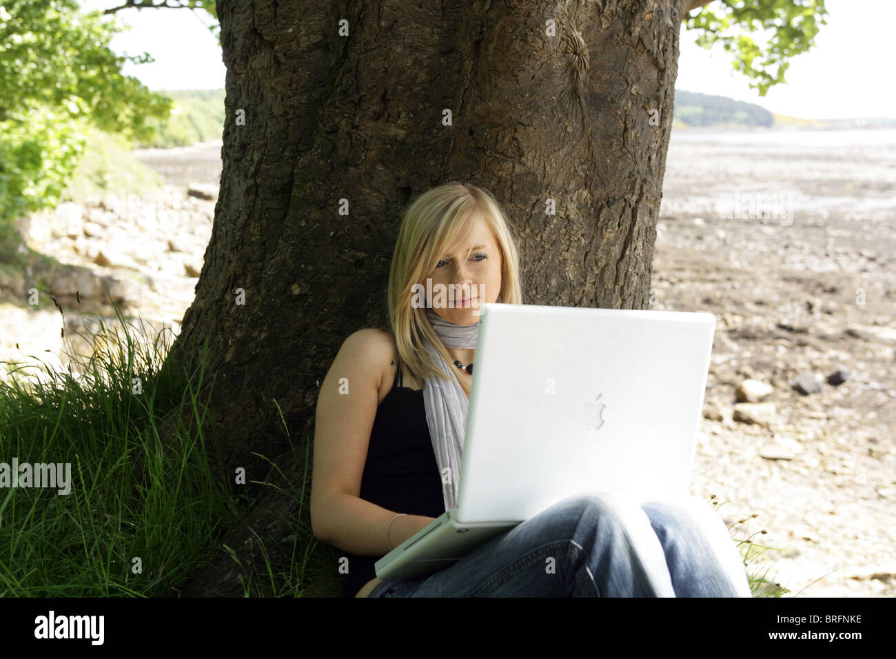 Young woman sitting outside using her apple laptop Stock Photo - Alamy