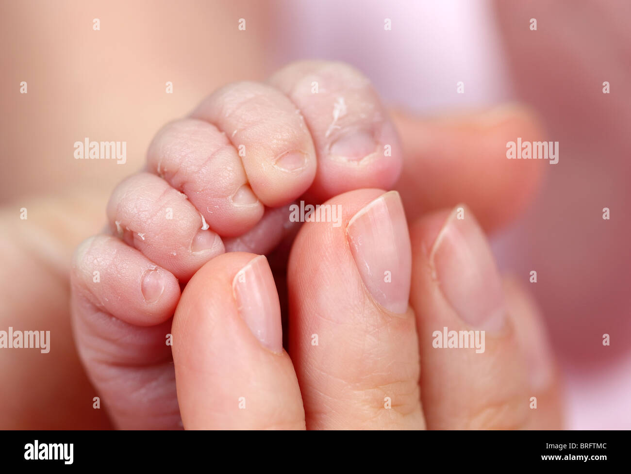 Foot of newborn baby and mothers fingers Stock Photo - Alamy
