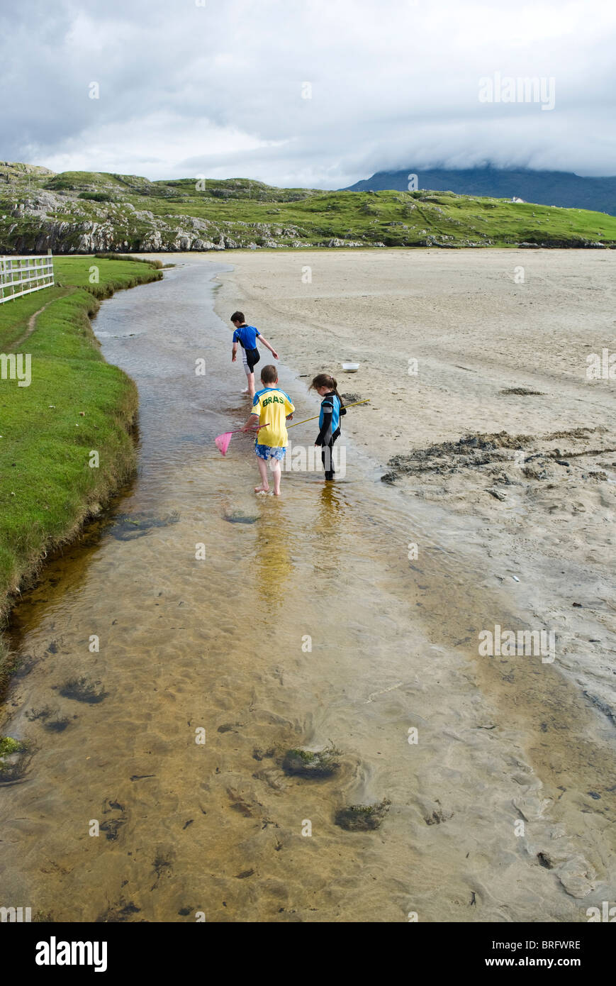 Children playing in a stream which comes down from Mweelrea mountain in ...