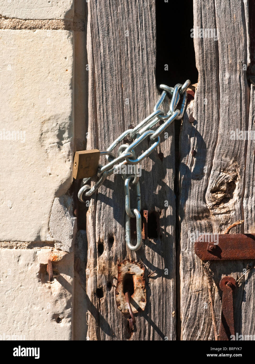 New lock and chain fastening old barn door - France Stock Photo - Alamy