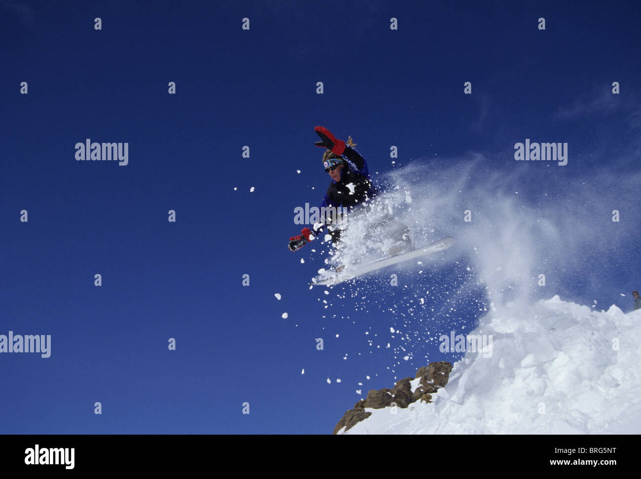Male snowboarder flying through the air Stock Photo - Alamy
