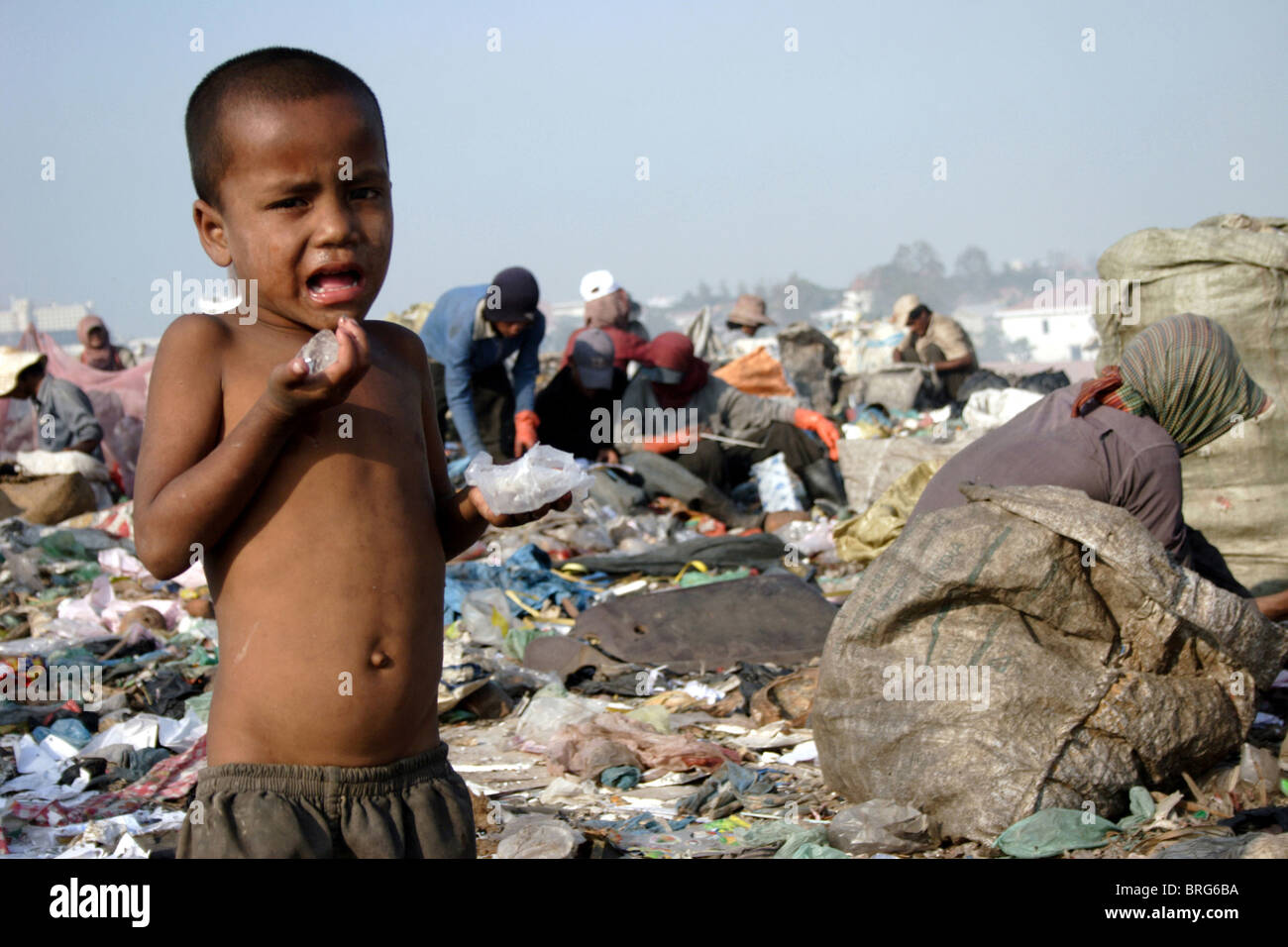 A young boy who is a child laborer takes time out to cool off at the ...