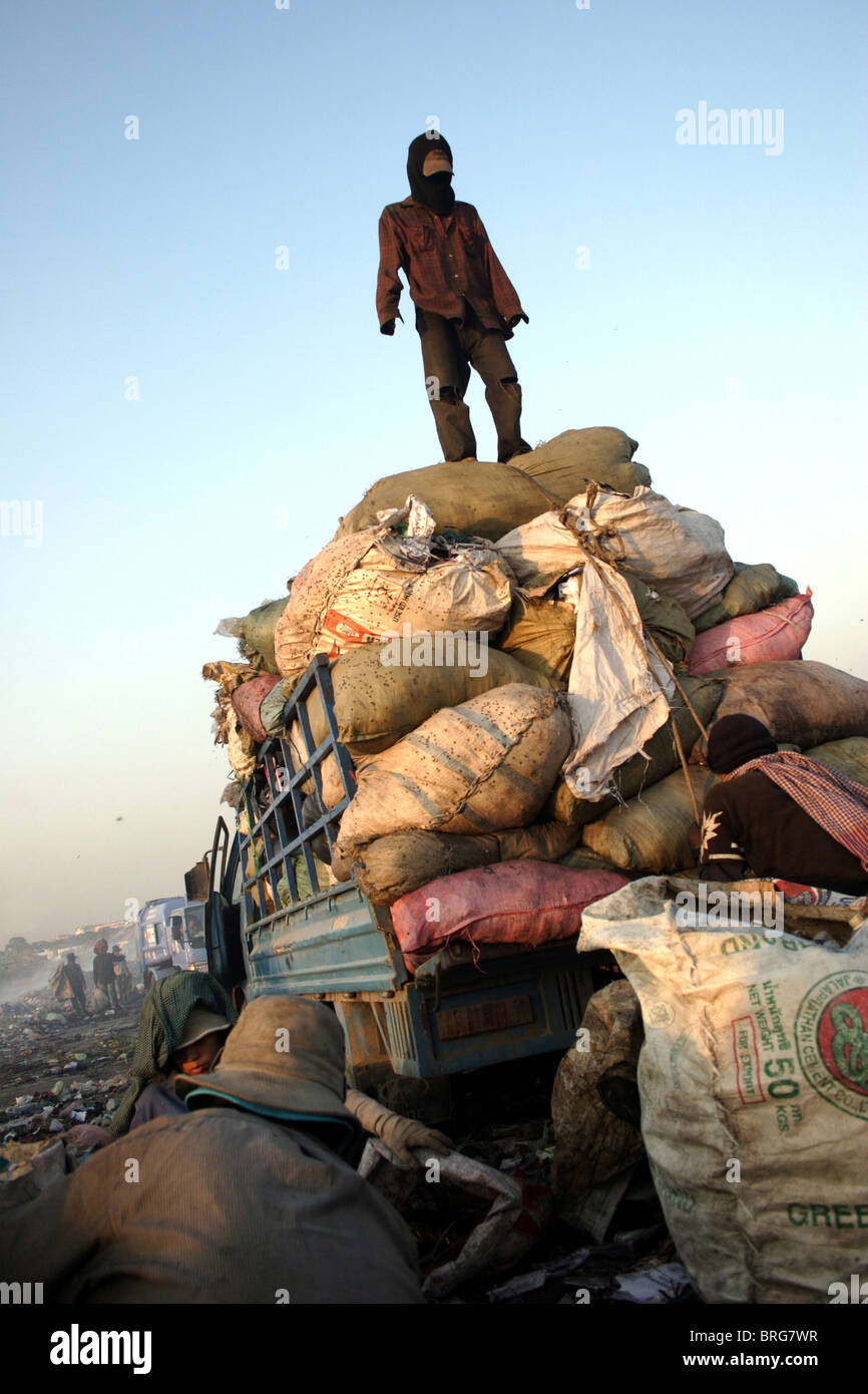 A man stands on a pile of sacks being transported to recycling ...