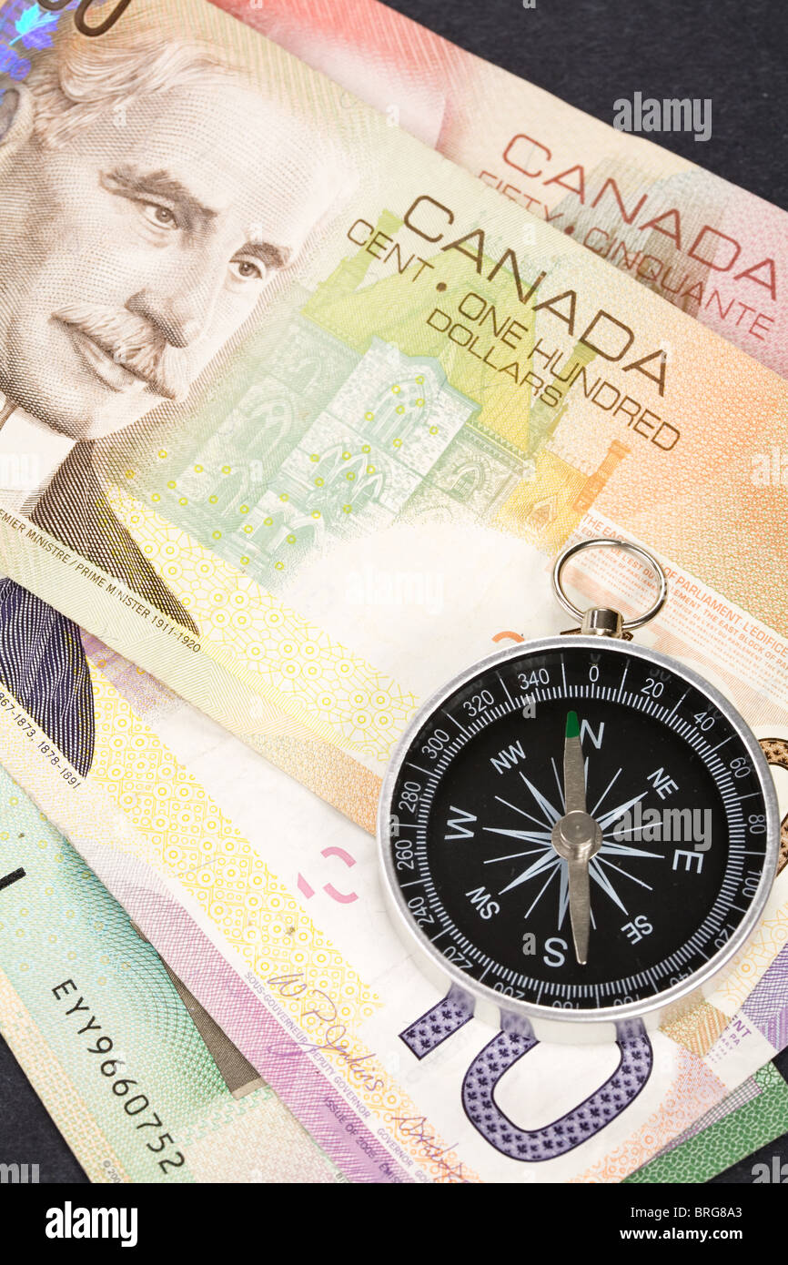 Compass and canadian dollar close up shot Stock Photo - Alamy