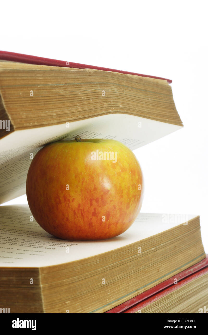Close up of apple and old books on white background Stock Photo - Alamy