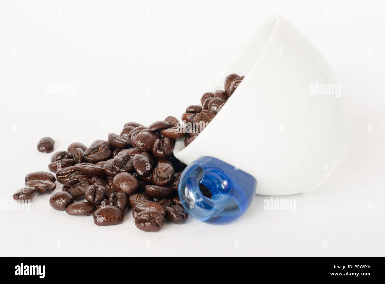 Beans overflowing from a coffee cup Stock Photo - Alamy