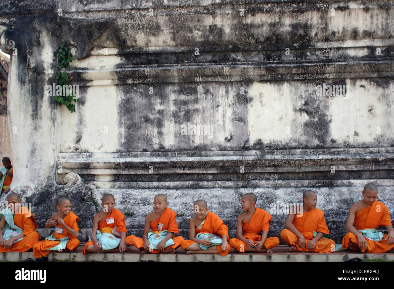 Novice monks pray and study at the base of a large stupa at historic ...