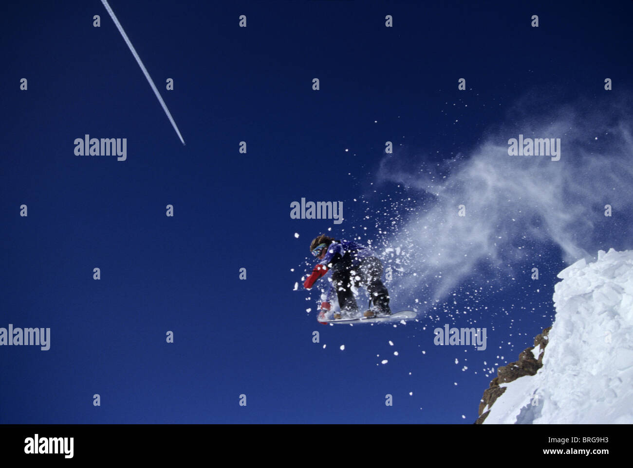Male snowboarder flying through the air Stock Photo - Alamy